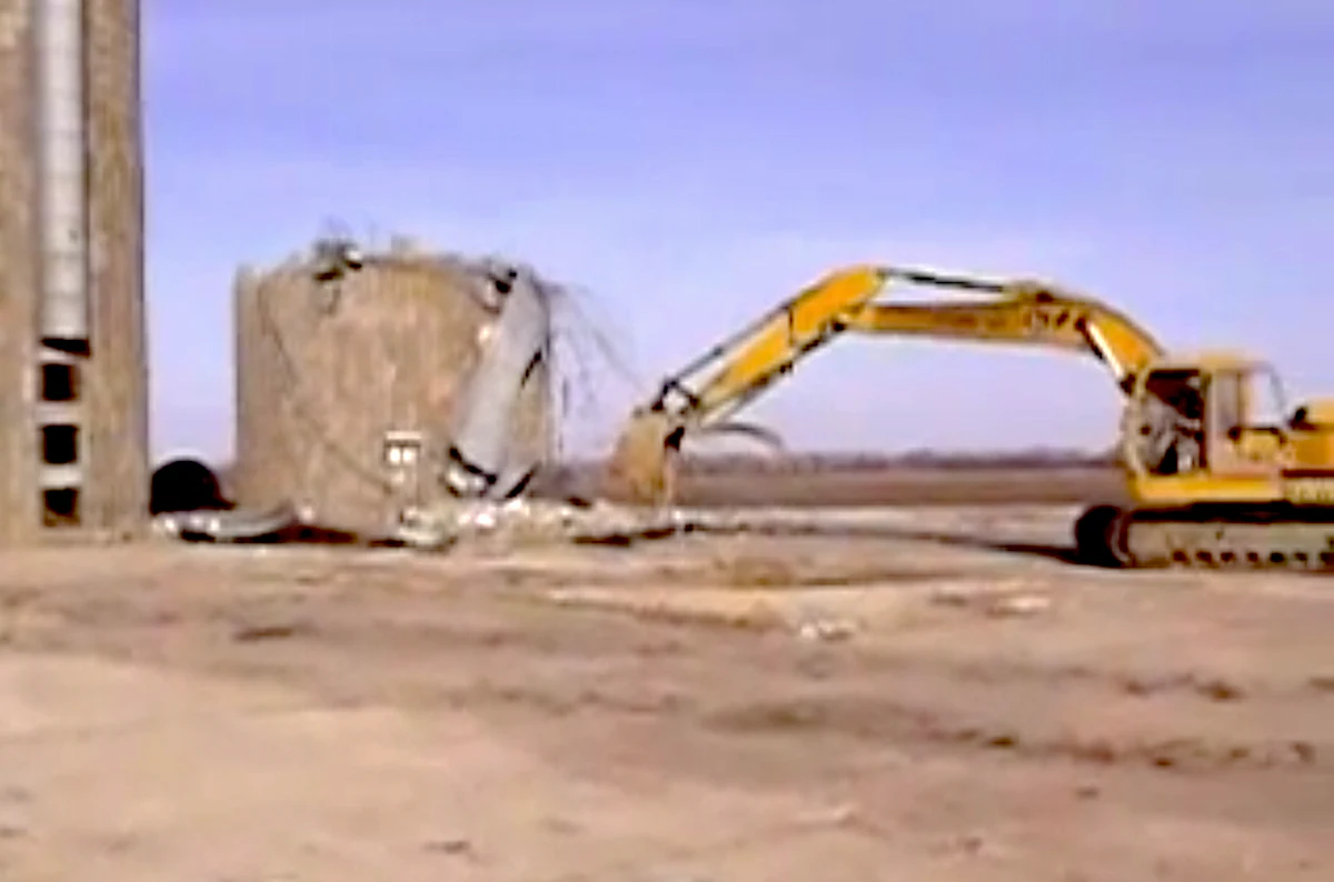 Excavator unravels a silo into a crumbled heap with a single yank of ...